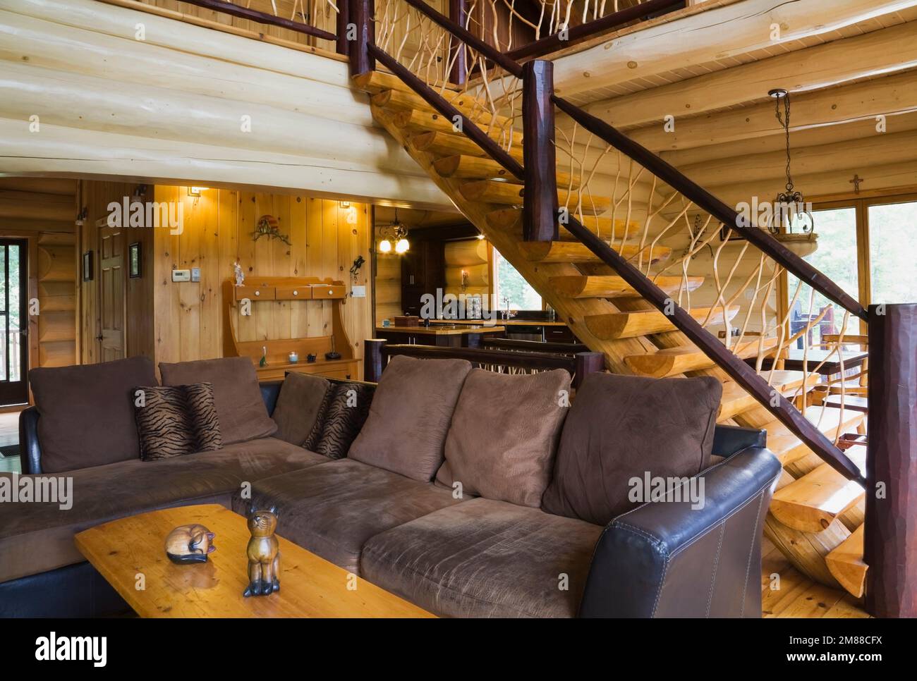 Wooden coffee table and brown leather L shaped sofa set in living room ...