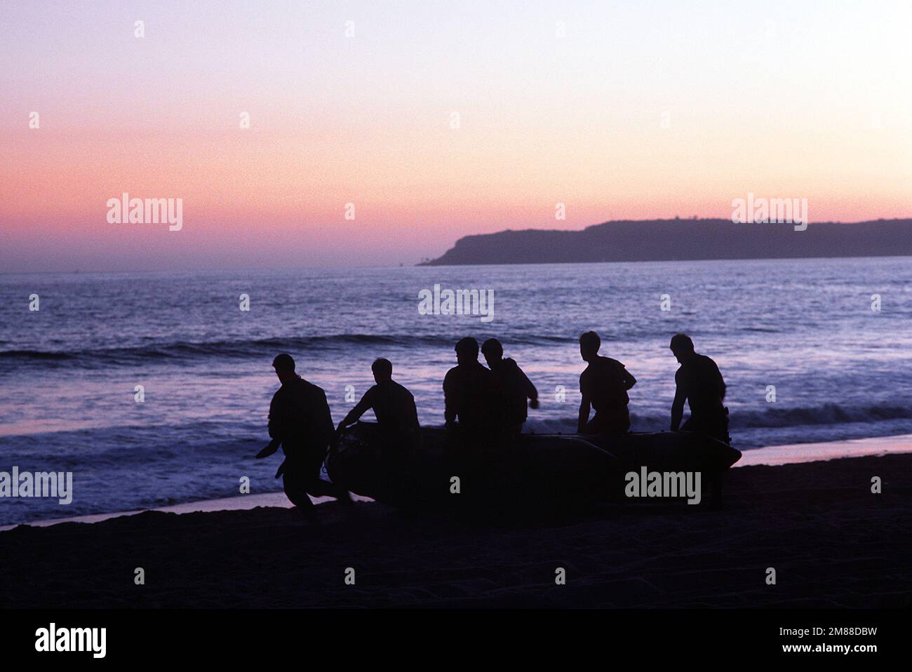 Members of U.S. Navy Sea-Air-Land (SEAL) Team Five carry a raft into ...