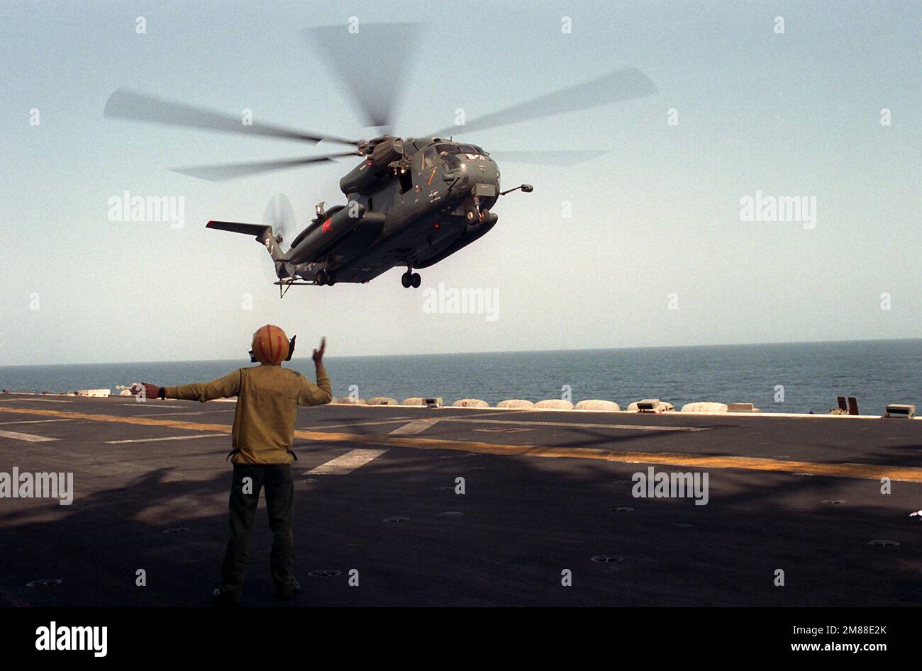 A plane director guides a Helicopter Mine Countermeasures Squadron 14 ...