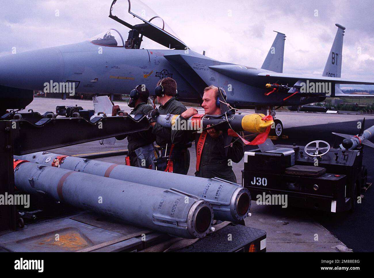 A 36th Tactical Fighter Wing ground crew carries an AIM-9 Sidewinder ...