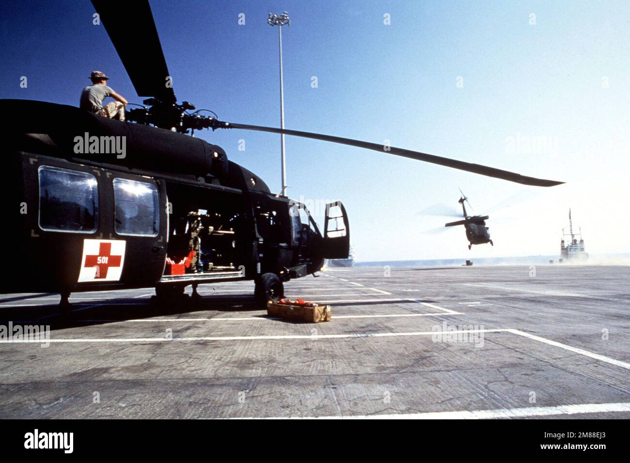 A UH-60 Blackhawk helicopter takes off as another stands by after ...