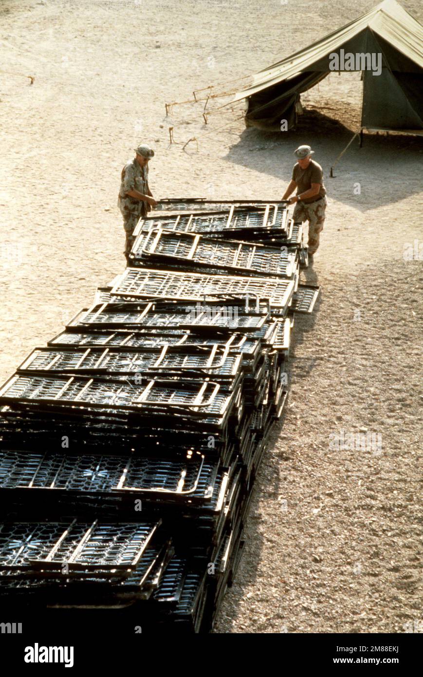 US Navy personnel stack cot frames for shipment as they dismantle their ...