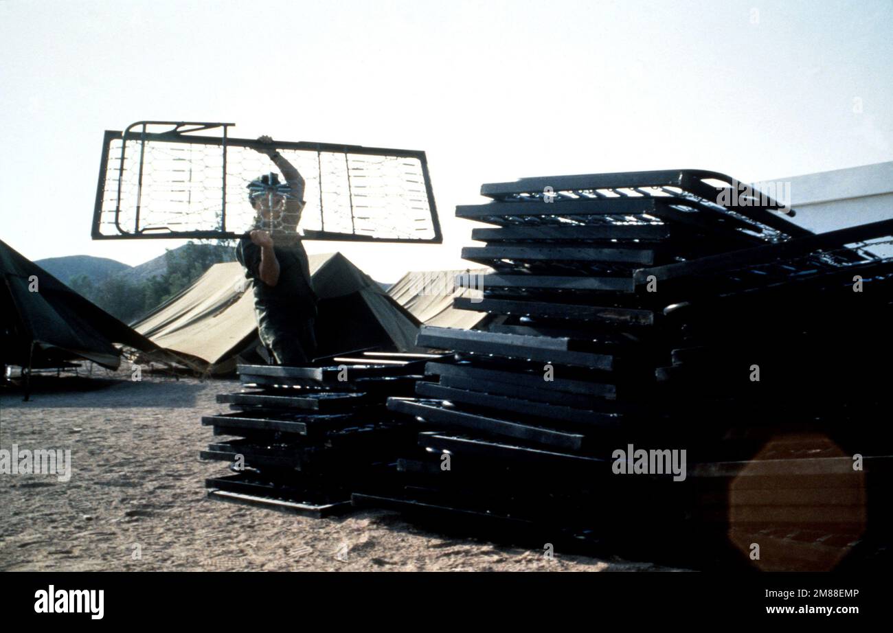 US Navy personnel stack cot frames for shipment as they dismantle their ...