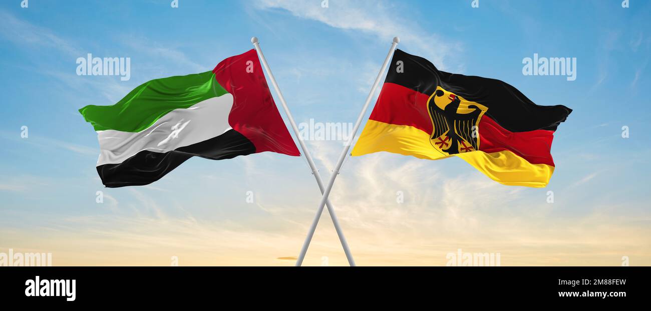 two crossed flags Germany and United Arab Emirates waving in wind at ...