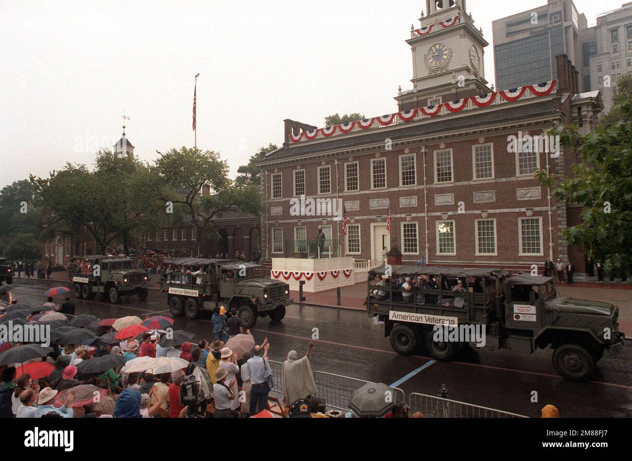 Trucks carrying American war veterans pass down the street during a ...