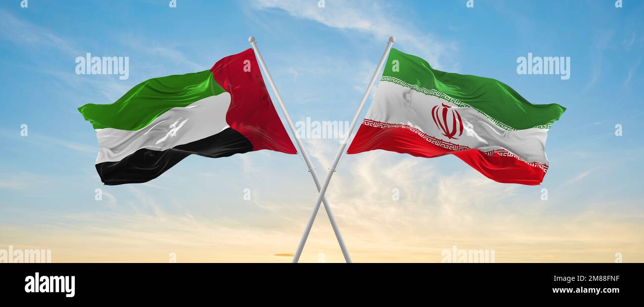 two crossed flags Iran and United Arab Emirates waving in wind at ...