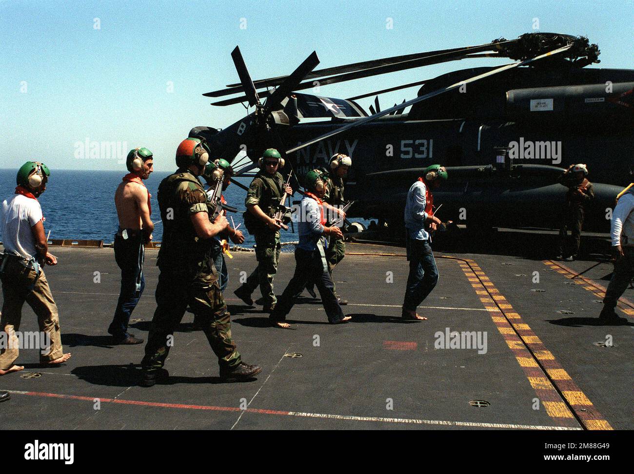 Iran detainees wearing helicopter headgear and hearing protection are ...