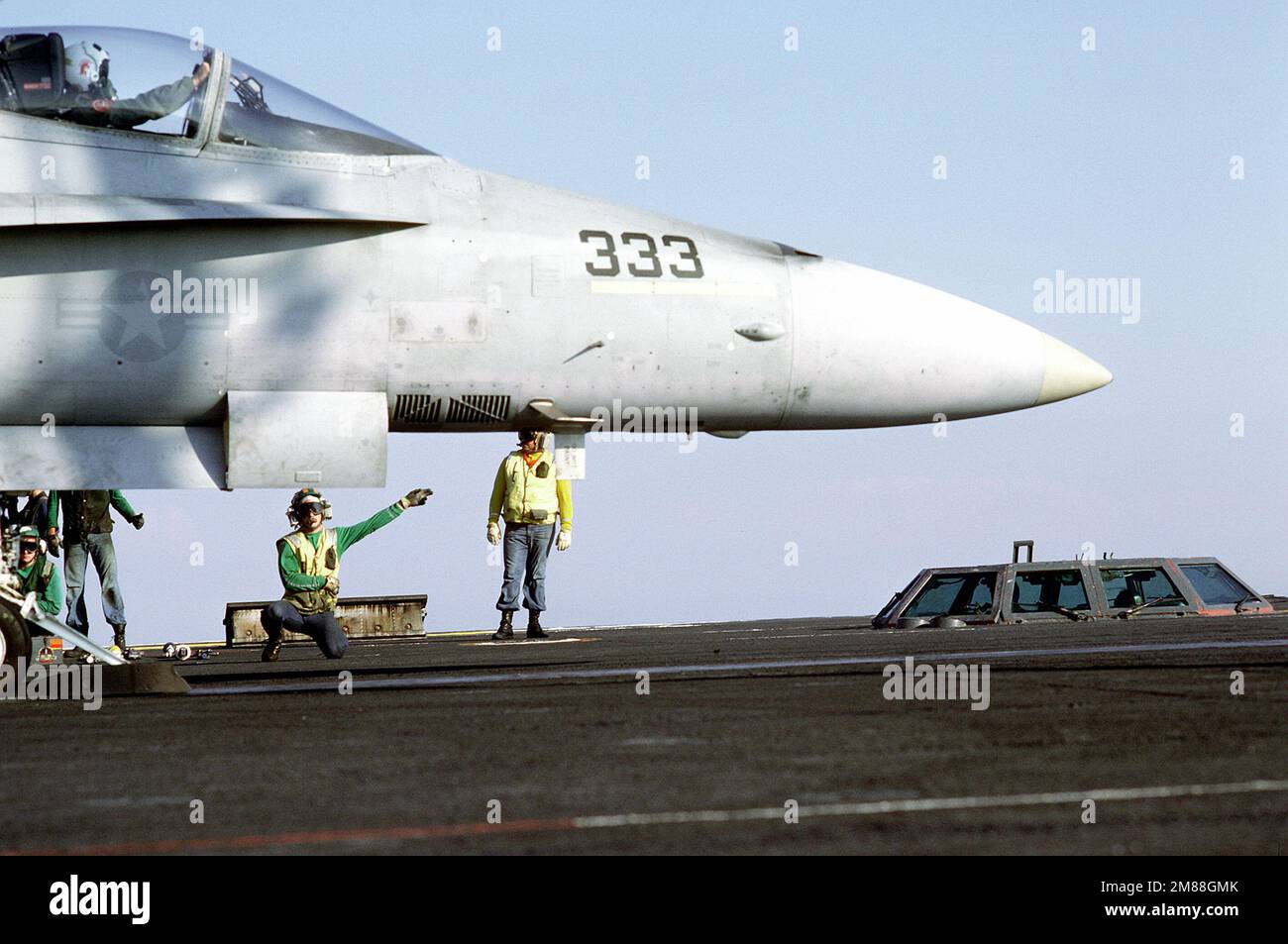 A catapult crew member signals as a Strike Fighter Squadron 106 (VFA ...