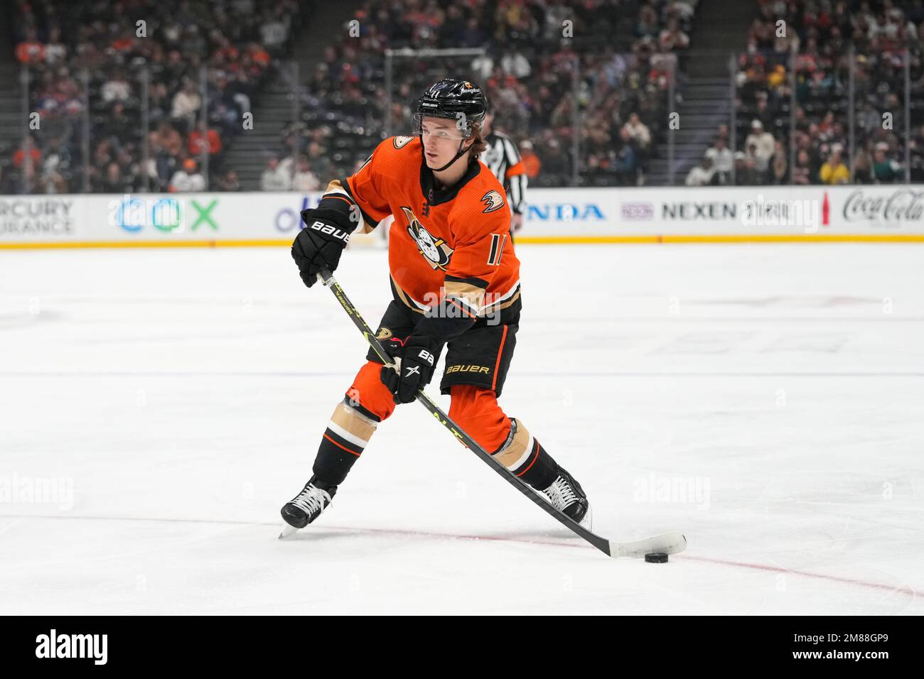 Anaheim Ducks' Trevor Zegras (11) hits the puck during the first period ...