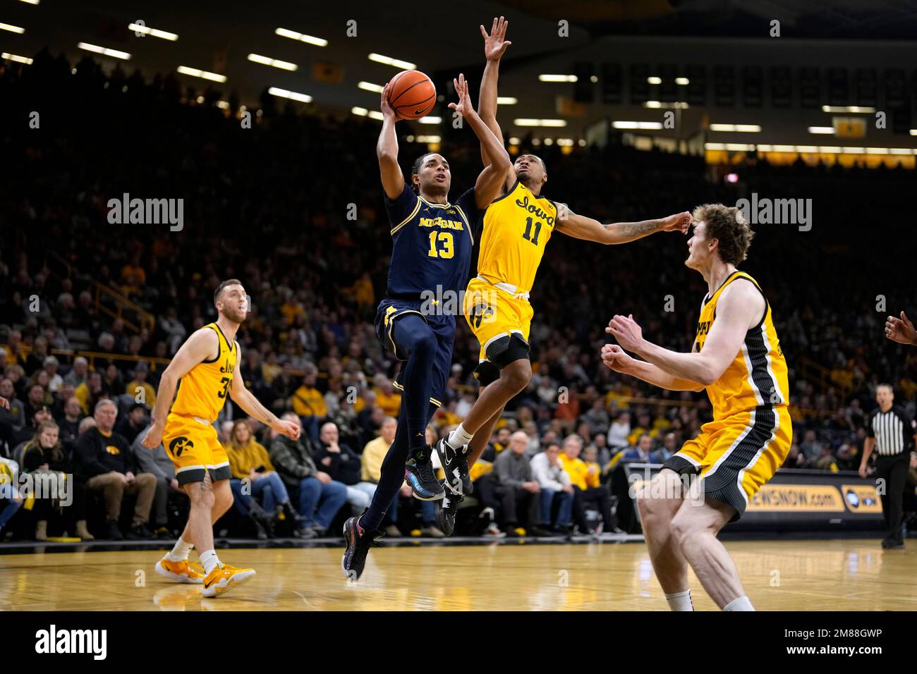 Michigan guard Jett Howard (13) drives to the basket past Iowa guard ...