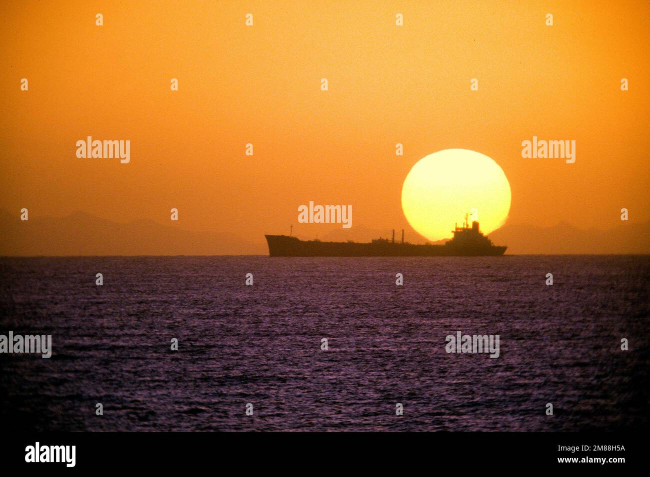 The setting sun silhouettes the transport oiler USNS SEALIFT CHINA SEA ...