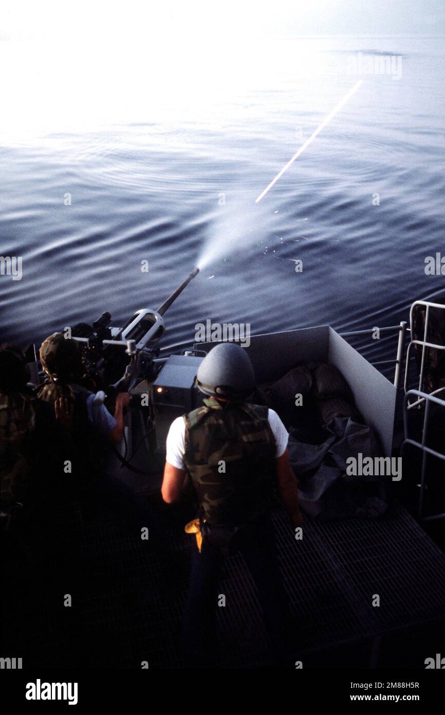 A crewman fires a 25mm Mark 38, Mod O gun system during gunnery ...