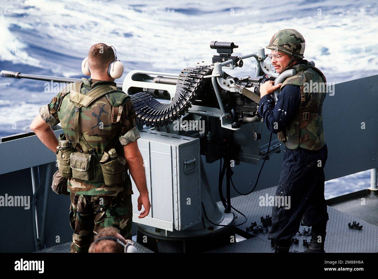 A GUNNERY Division 4 gunner's mate pauses after firing a burst from a ...