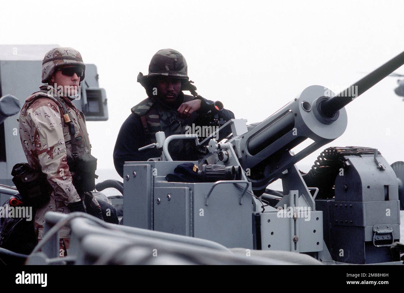 A GUNNERY Division 4 gunner's mate mans a 25mm Mark 38, Mod 0 gun ...