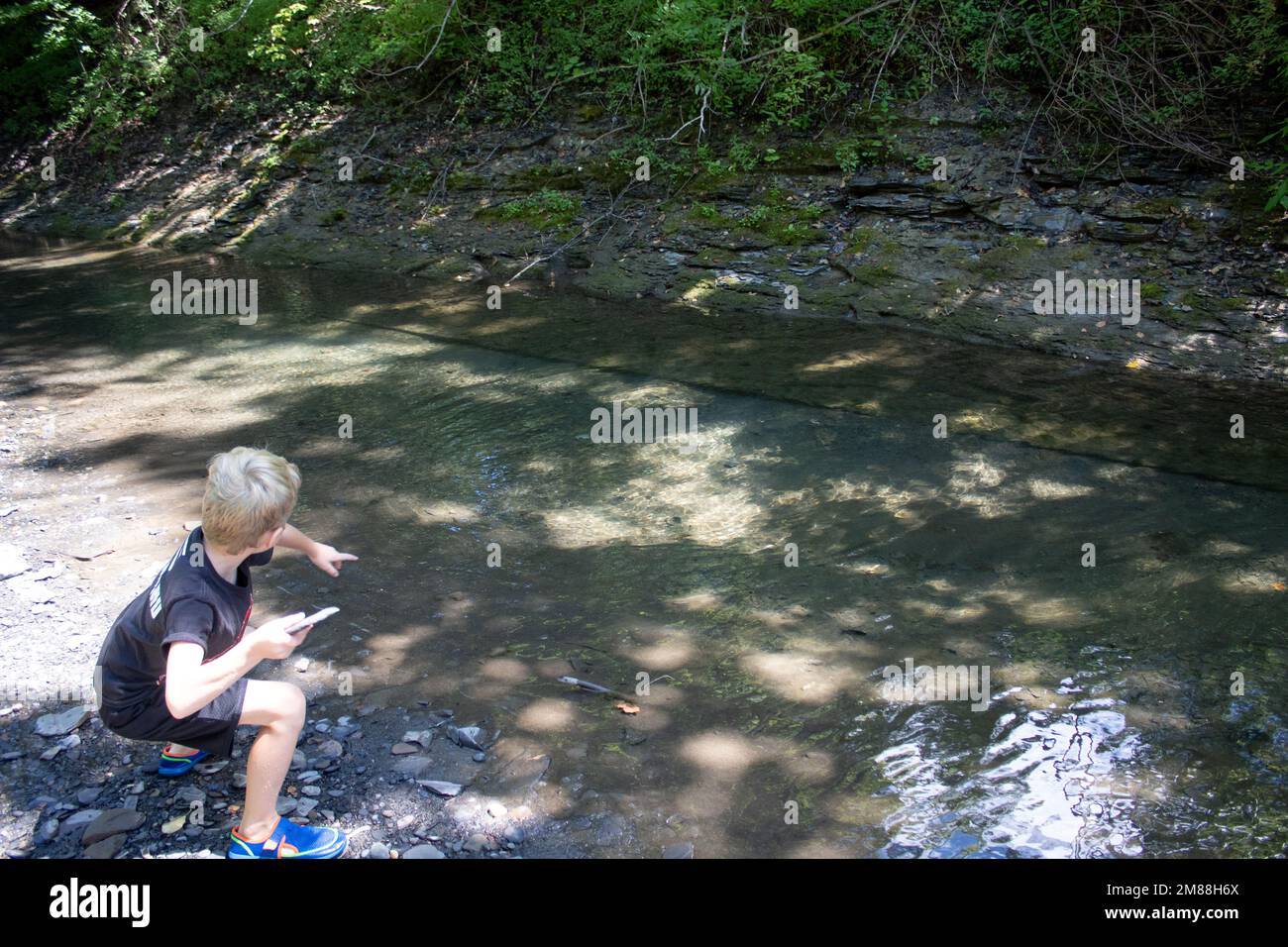 Boy playing in a river Stock Photo - Alamy