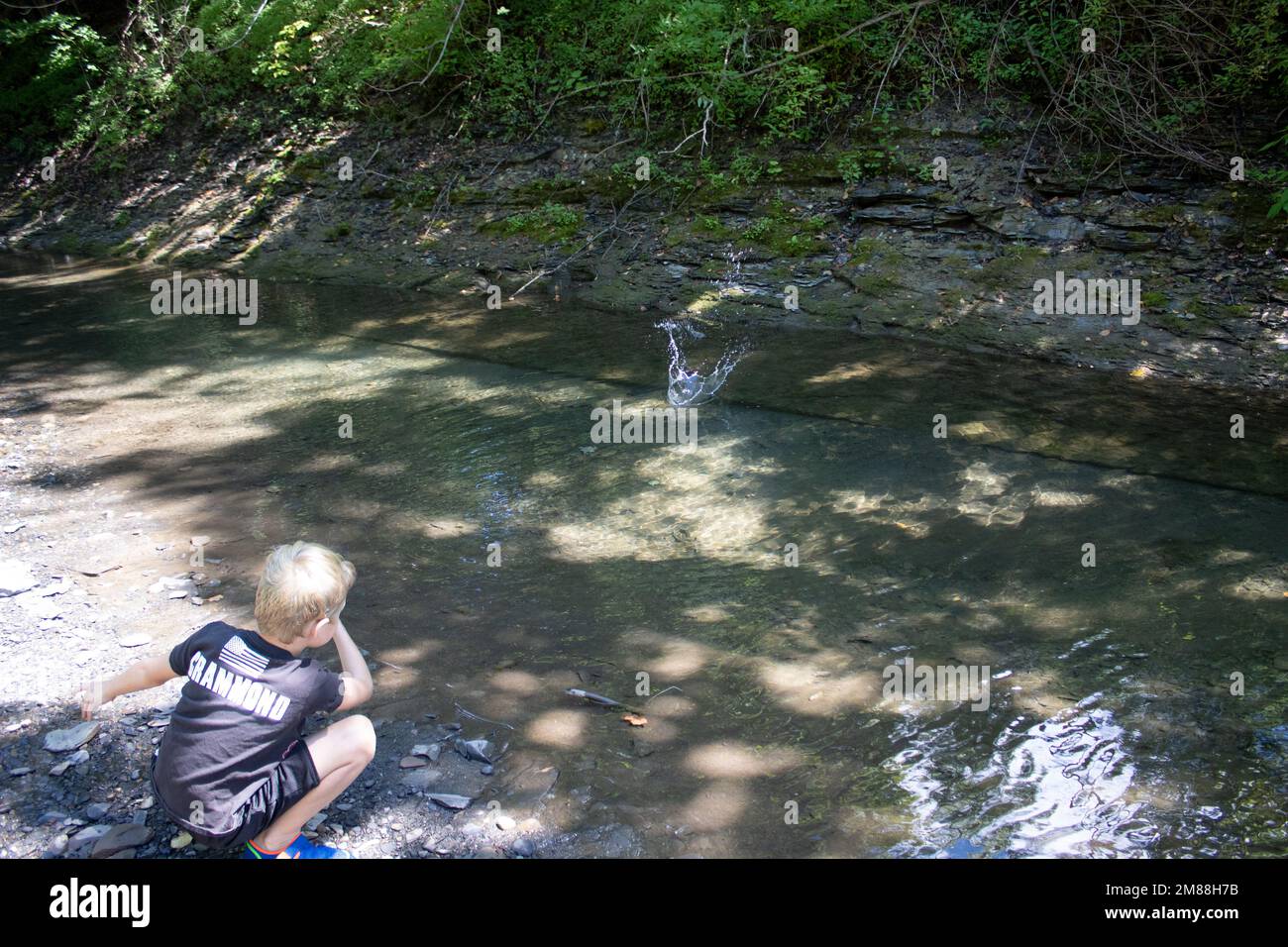 Boy playing in a river Stock Photo - Alamy