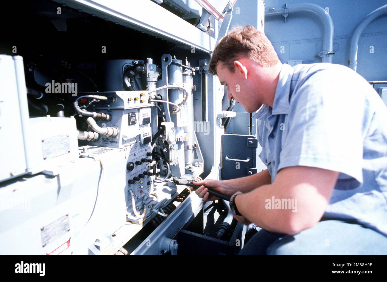 A fire control technician performs routine maintenance on the servo ...