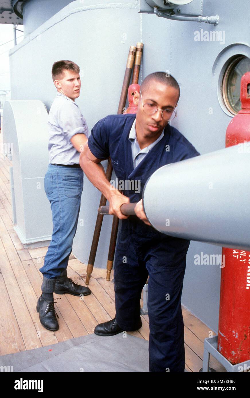 GUNNER's mates clean the barrel of a Mark 28 5-inch 38-caliber gun ...