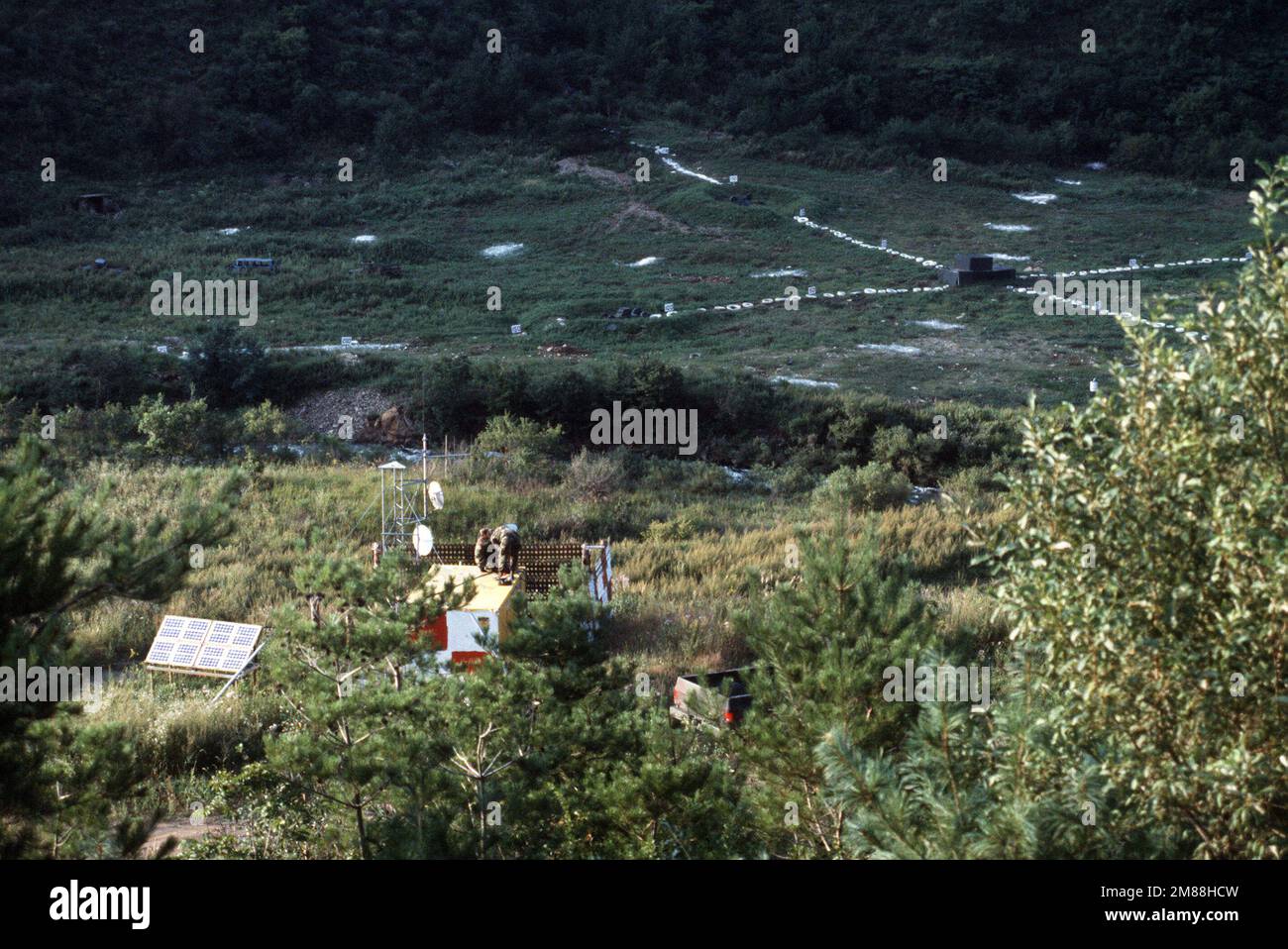 Two airmen work on a piece of equipment at the Pil Sung bombing range's ...