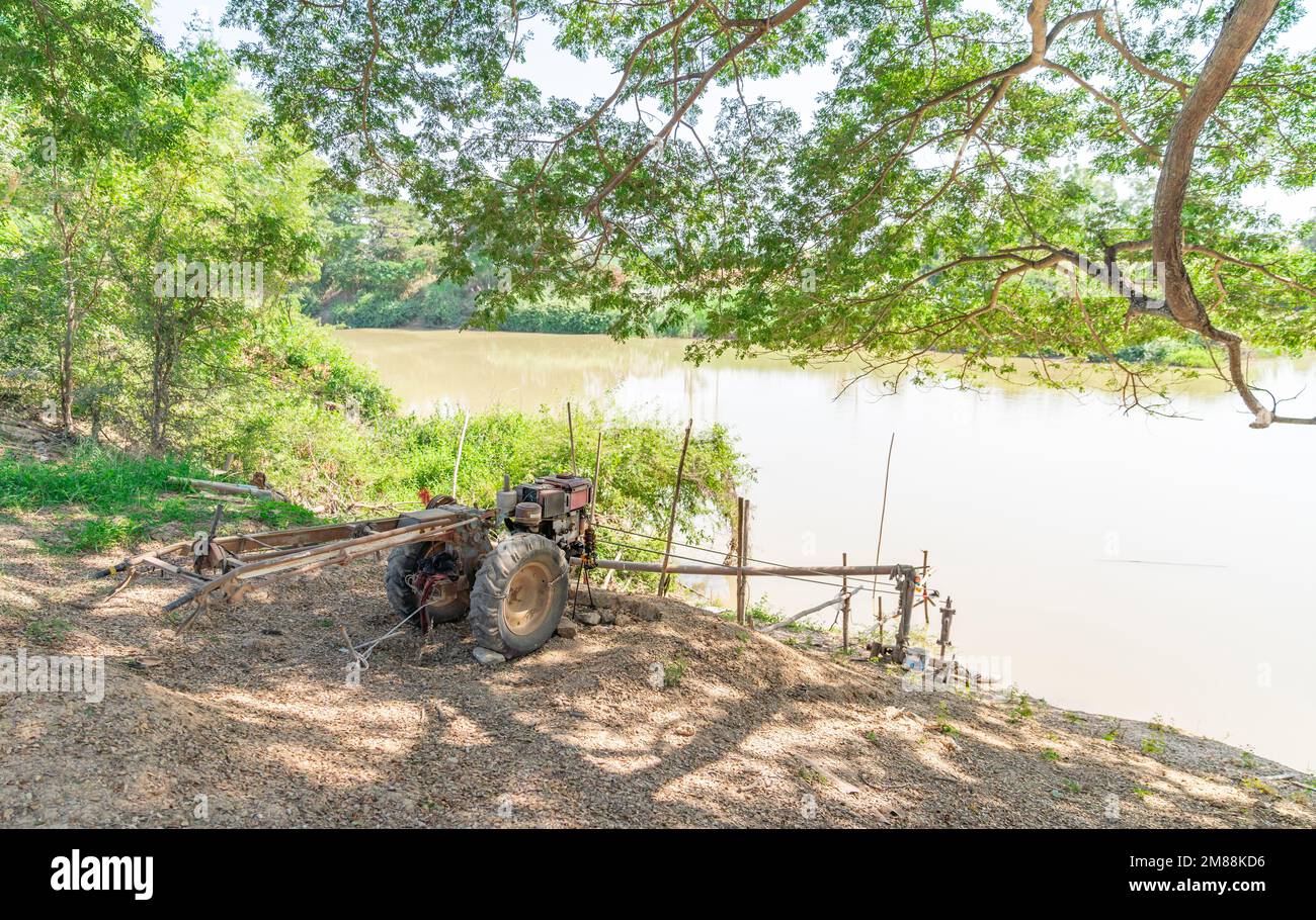 Farmers Pumping water to use in house with old tractor. Countryside ...
