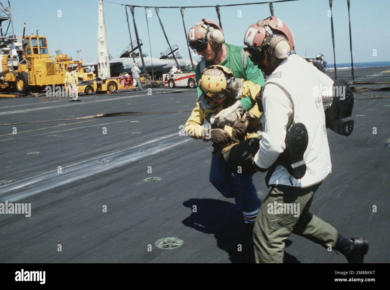 Flight deck crew members carry a simulated casualty across the Fight ...