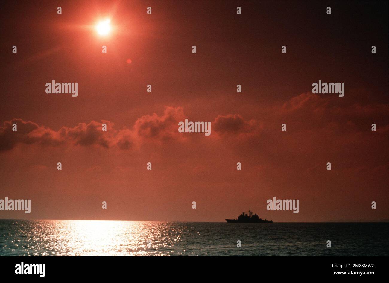 A silhouetted view of the guided missile cruiser USS YORKTOWN (CG 48) underway at sunset ...