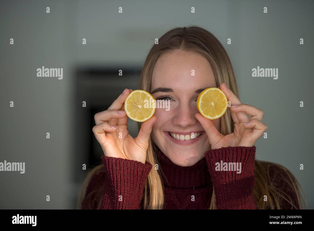 Young woman, cutting fruit, fooling around in the kitchen, having fun ...