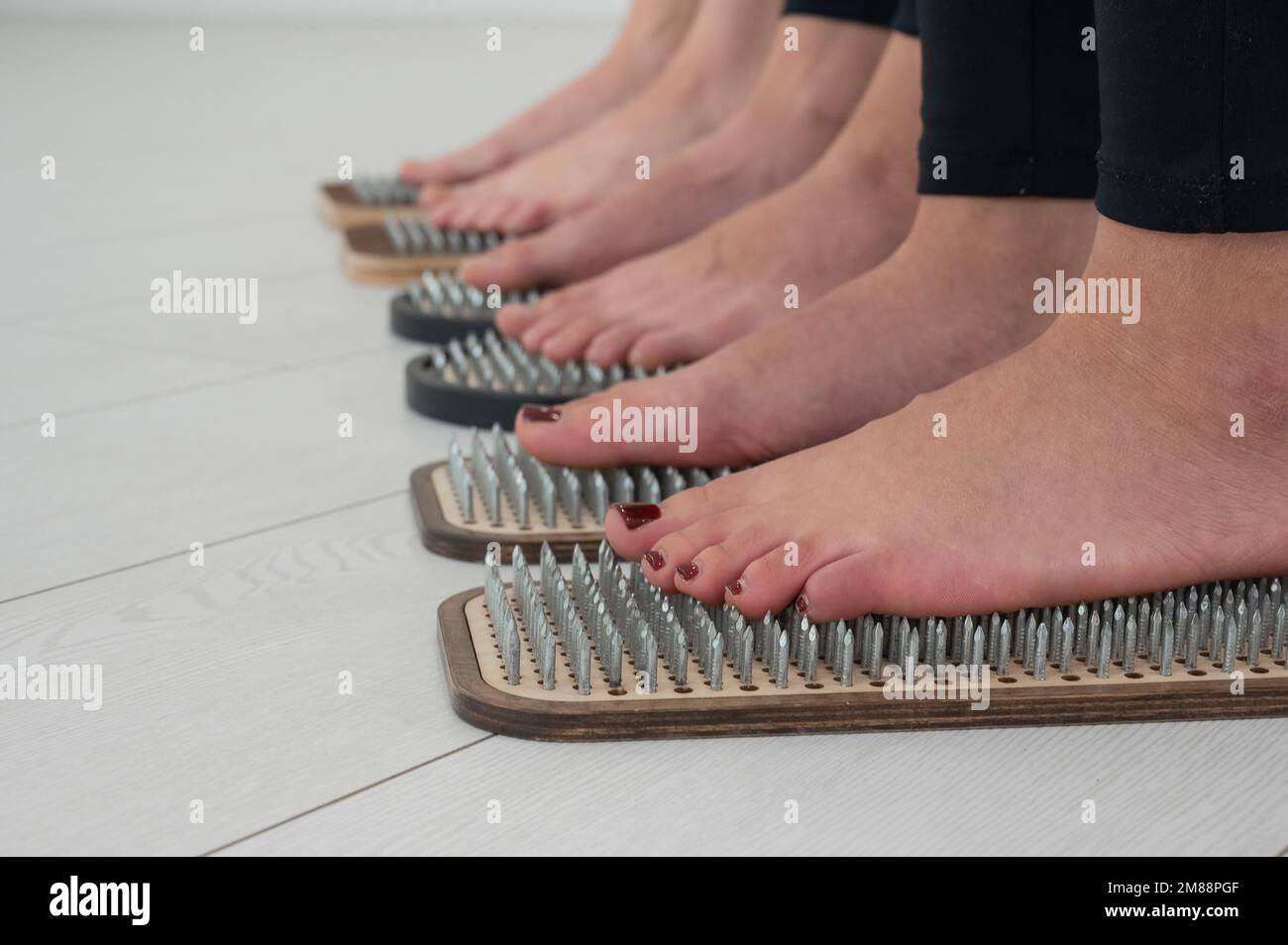 Close-up of three women's feet on sadhu's nails Stock Photo - Alamy