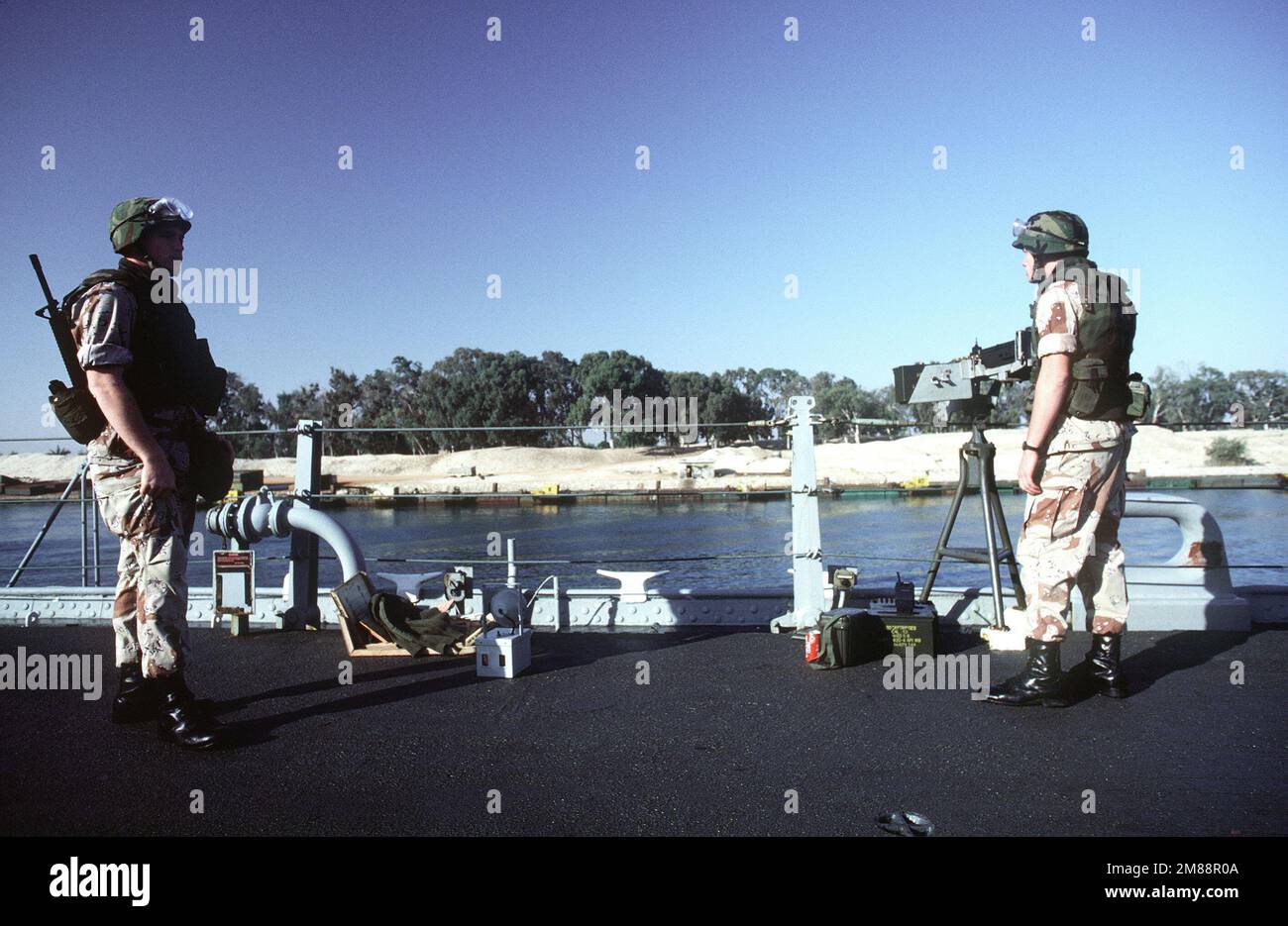 Marines, in camouflaged battle dress, man the ship's .50-cal. machine ...