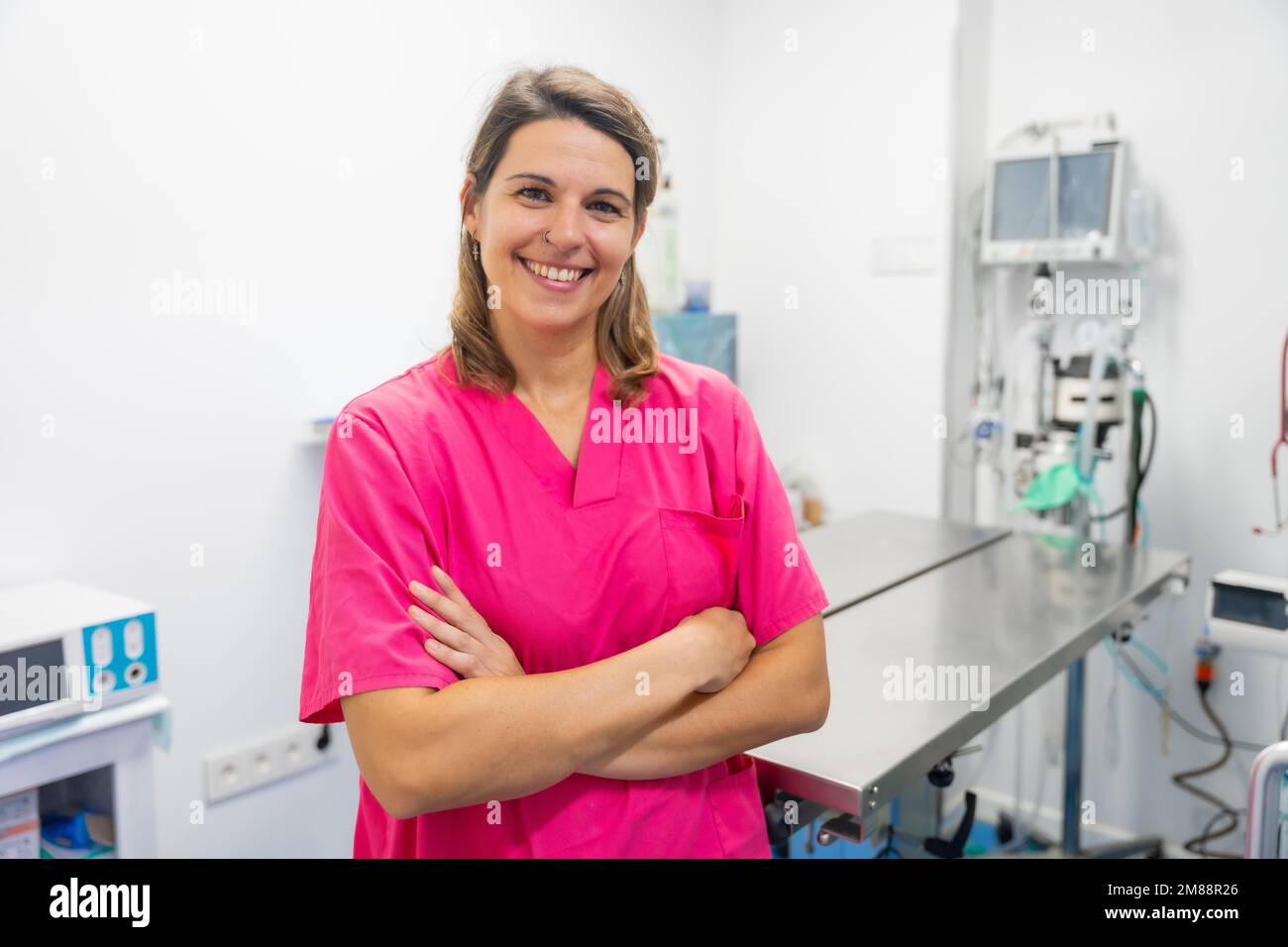 Portrait of a young female veterinarian at the vet clinic, arms crossed ...