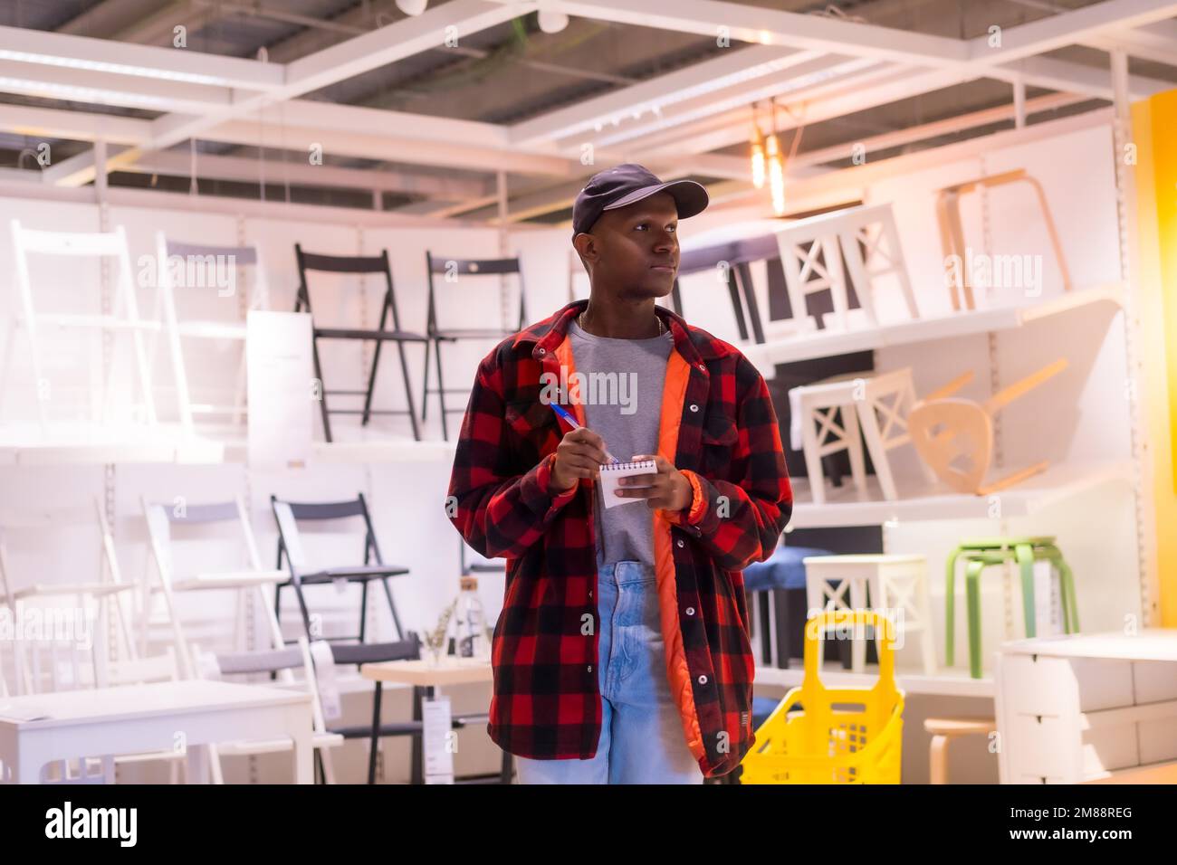 Black ethnic man shopping in a furniture store, looking at chairs Stock ...