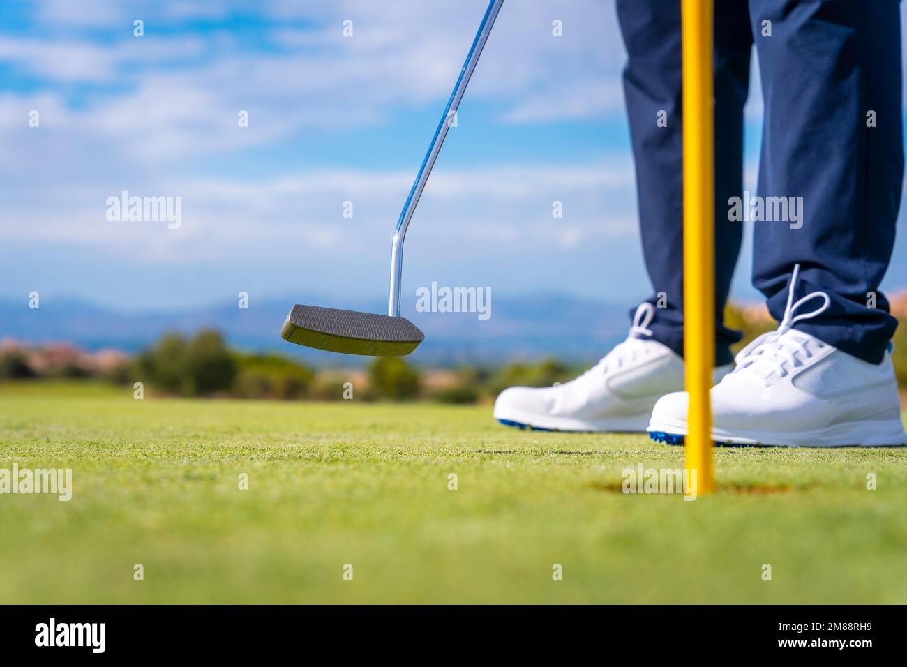 Hitting the green with the putter. The ball in the hole. man playing ...
