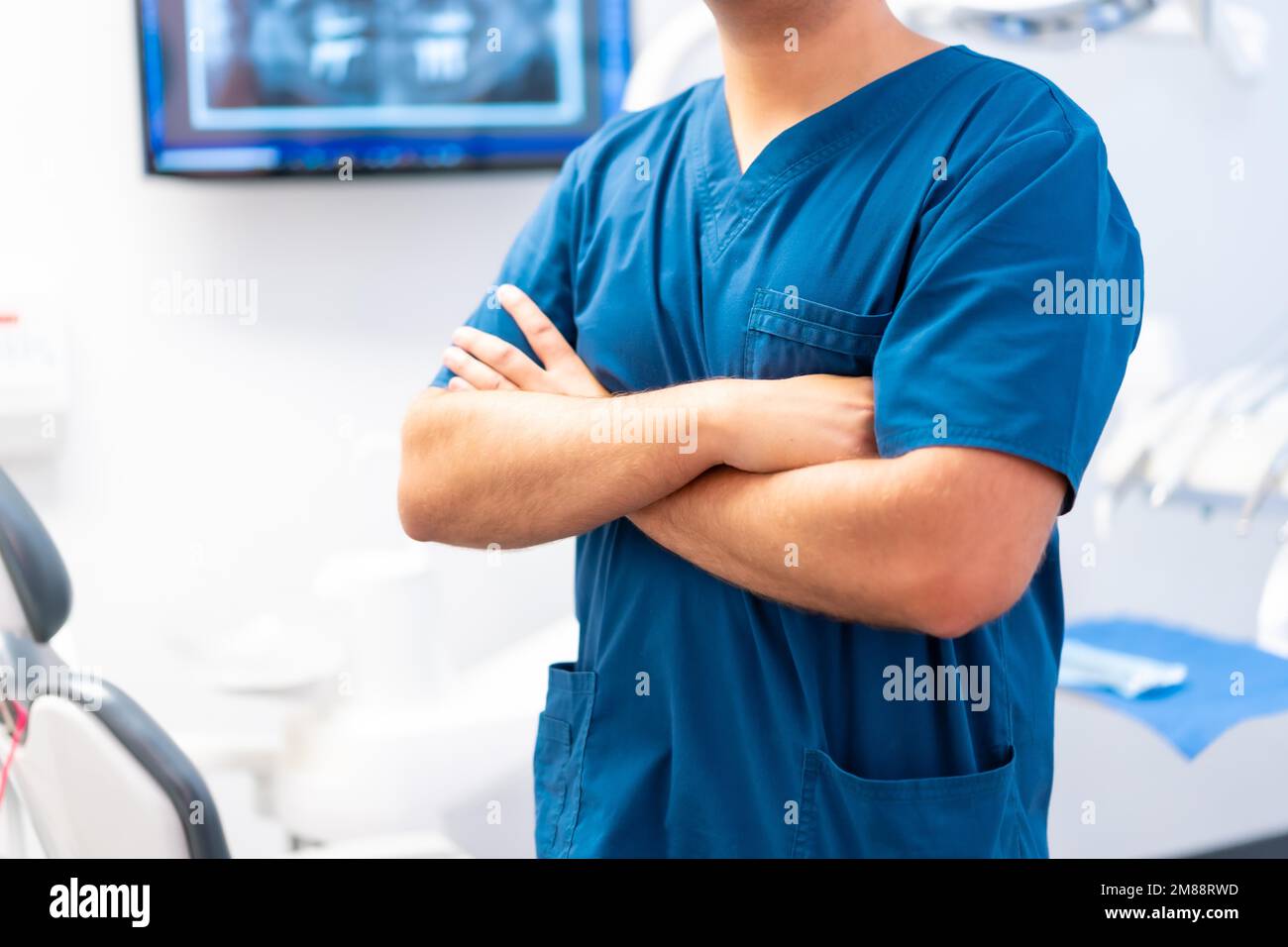 Dental clinic, unrecognizable caucasian male dentist with arms crossed ...