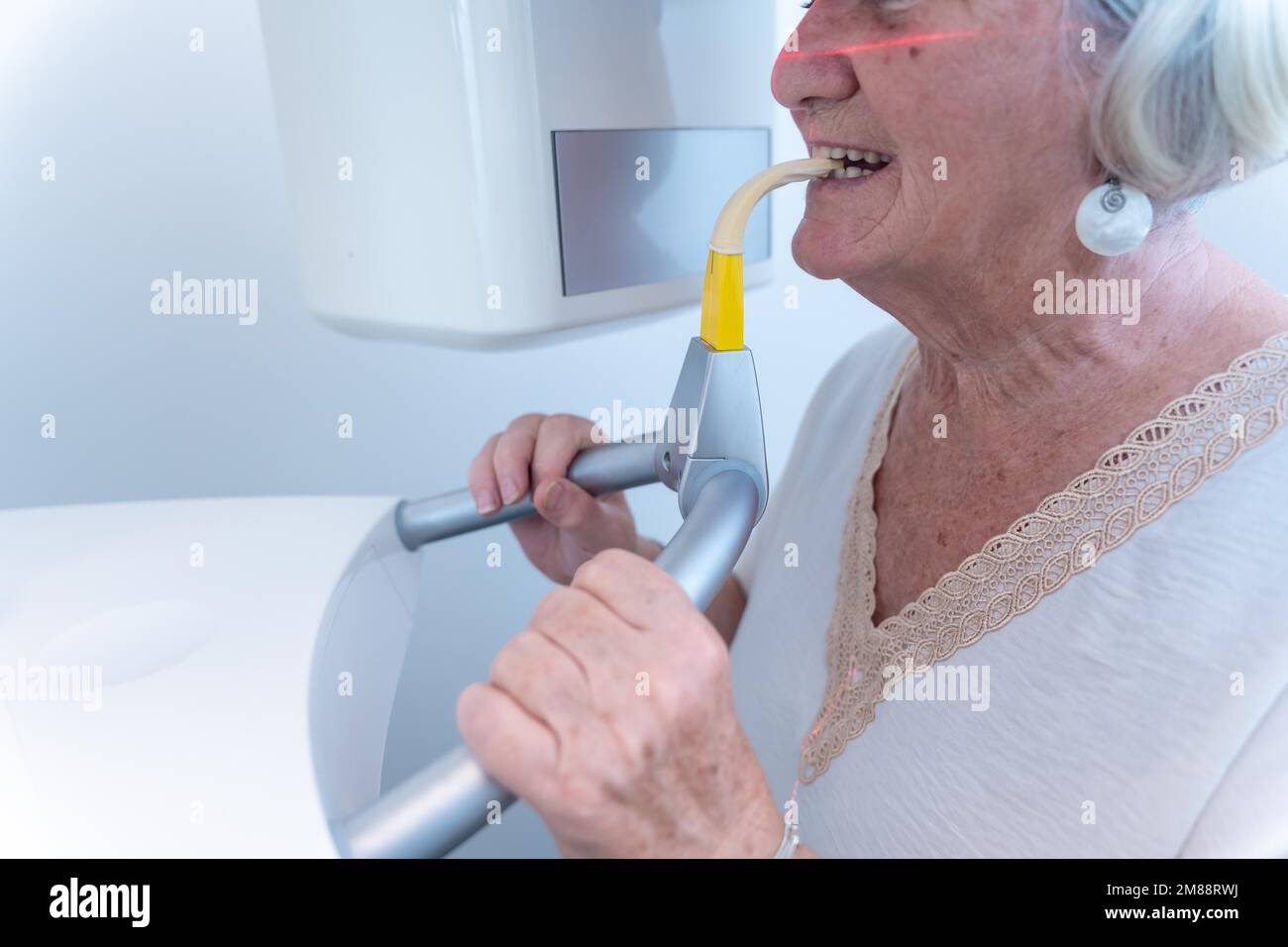 Dental clinic, detail of an elderly woman in the x-ray room, performing ...