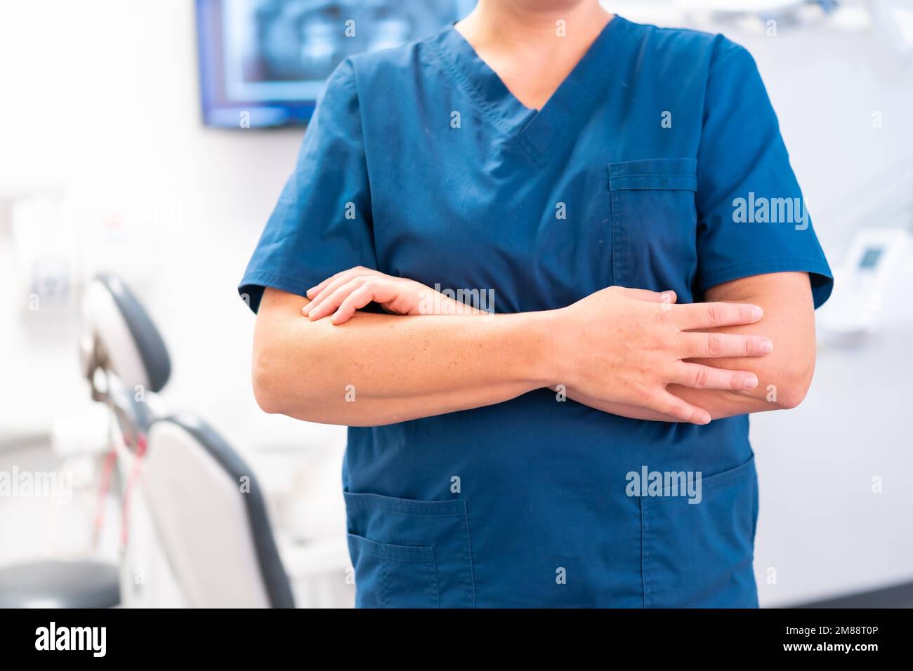 Dental clinic, unrecognizable caucasian female dentist with arms ...