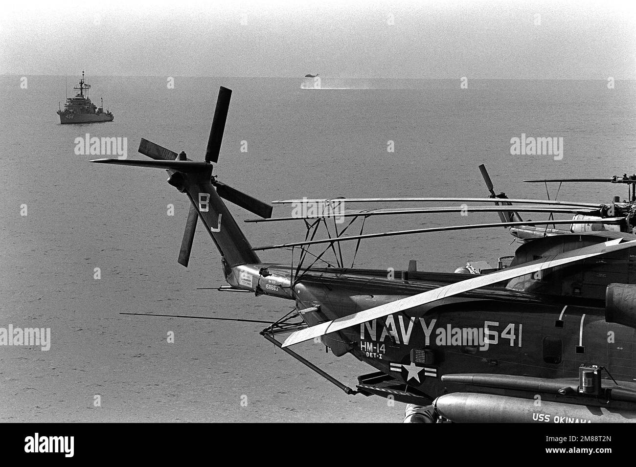 The ocean minesweeper USS INFLICT (MSO-456) and an RH-53D Sea Stallion ...