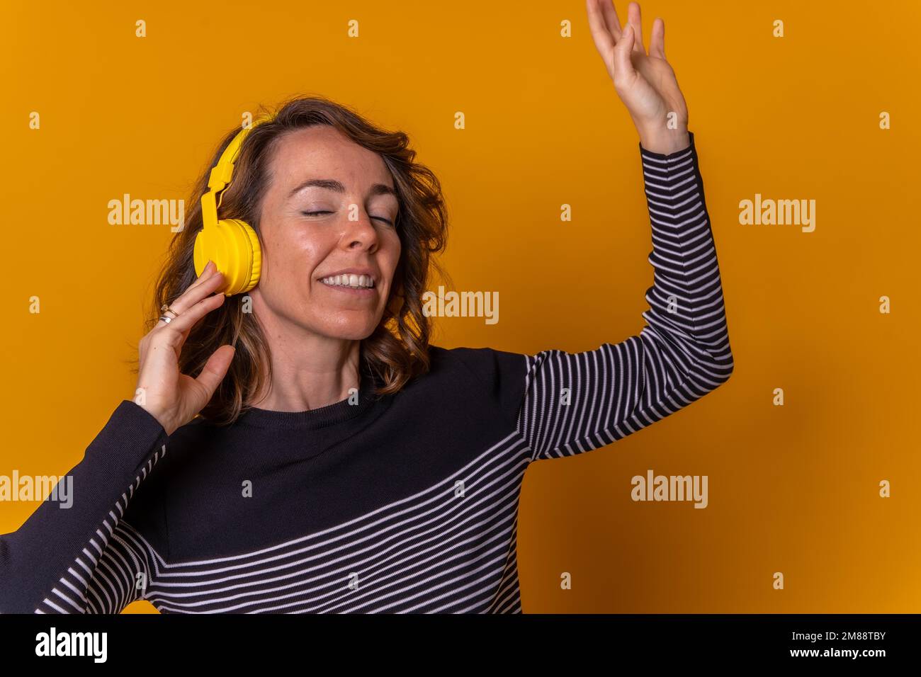 Caucasian girl listening to streaming music and smiling and dancing ...