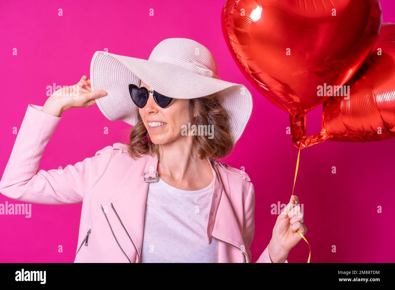 A blonde caucasian woman with a white hat and sunglasses in a nightclub ...
