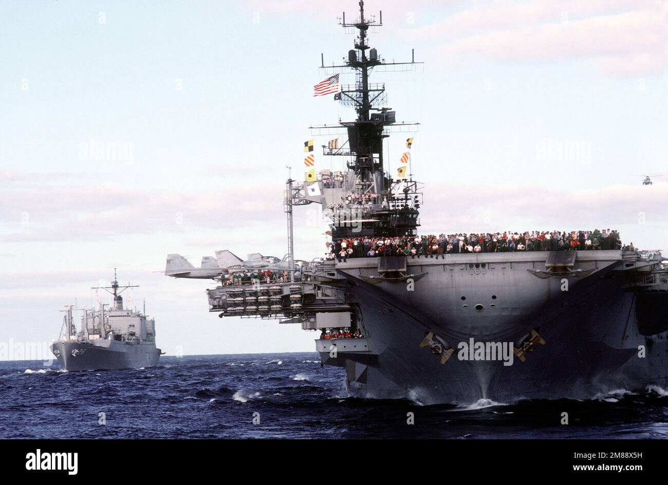 Crew members pose for a photo on the bow of the aircraft carrier USS ...