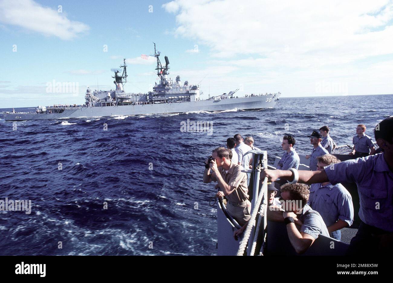 Crew members of the battleship USS IOWA (BB-61) look out over the rail ...