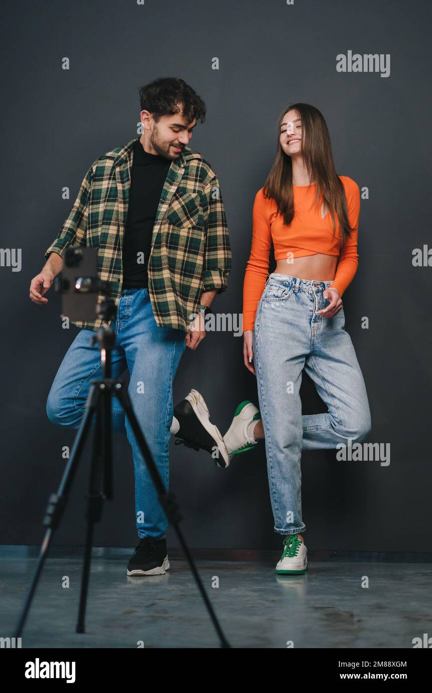 Young caucasian man and woman recording dance tutorial isolated over ...