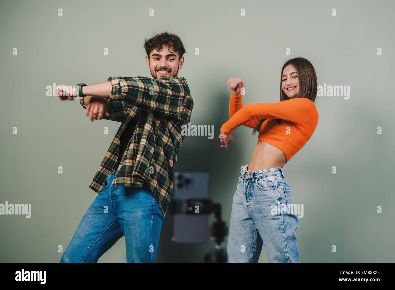 Dancing two young woman and man bloggers recording video in studio ...