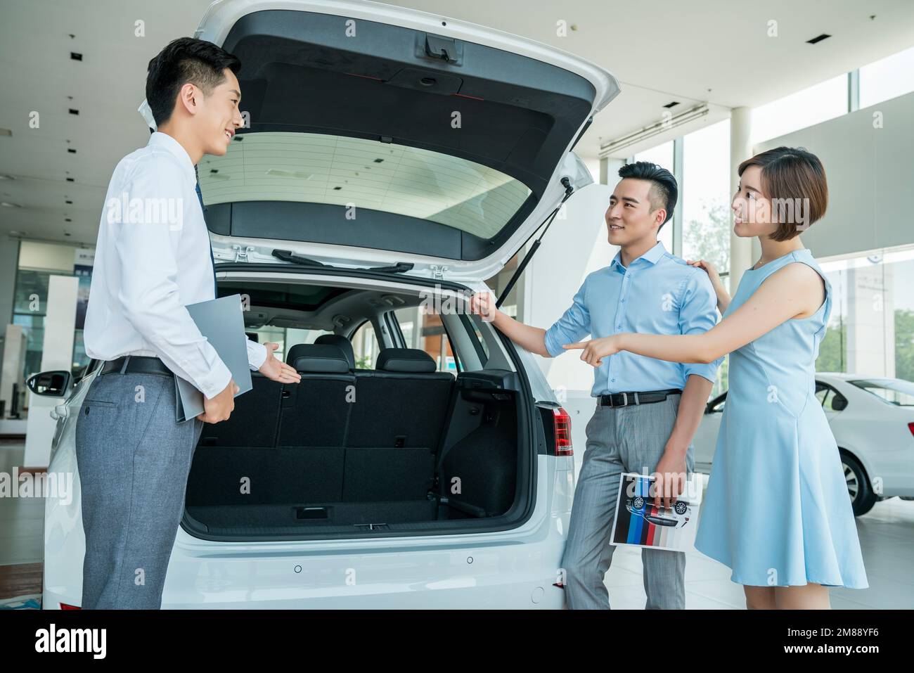 Young people in the car 4 s shop Stock Photo - Alamy