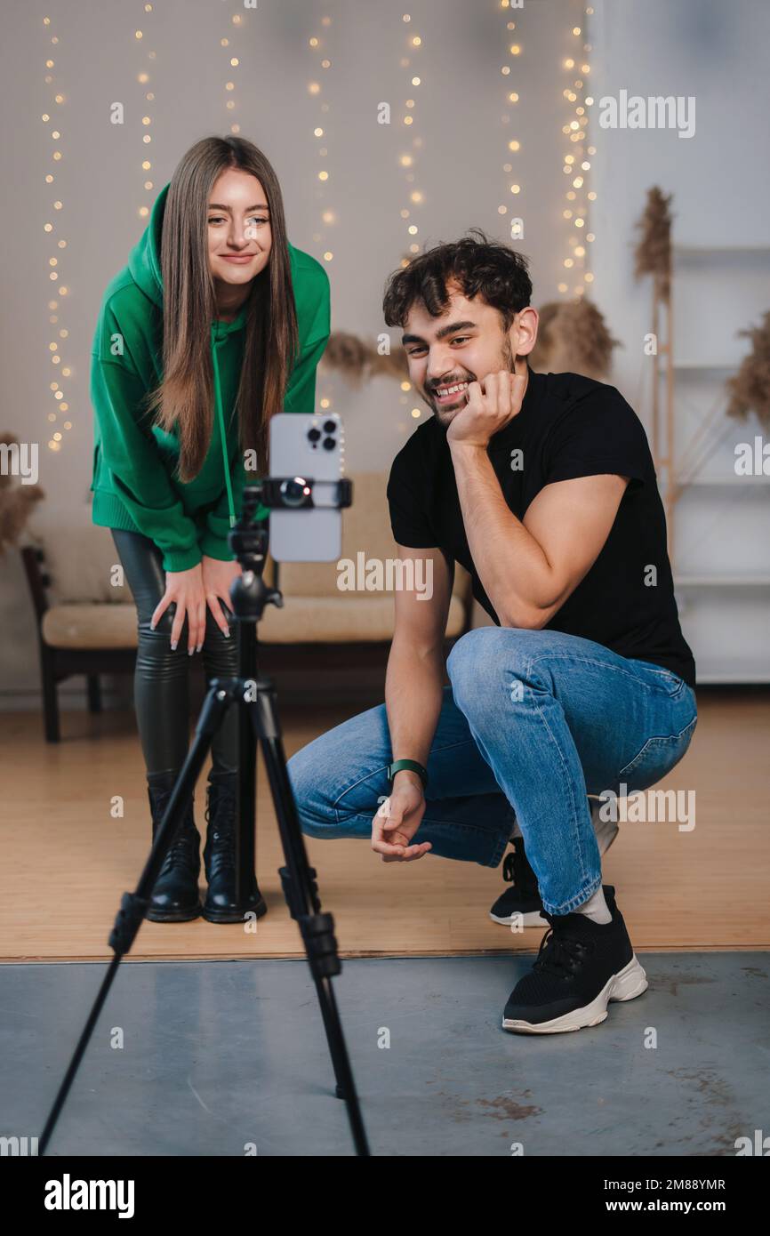 Young couple recording video content on smartphone camera at home ...