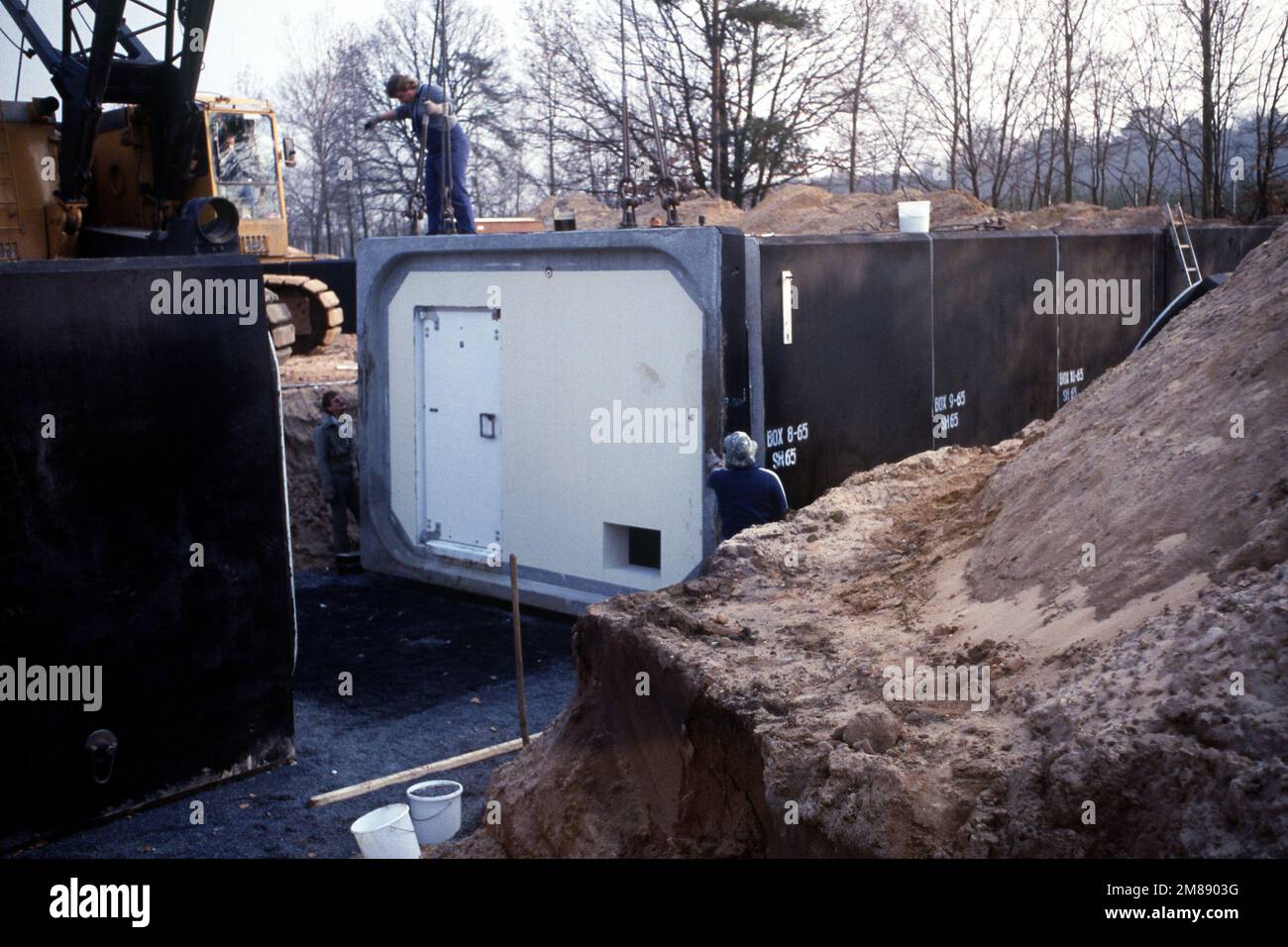 Workers assist in positioning a section of a prefabricated underground ...