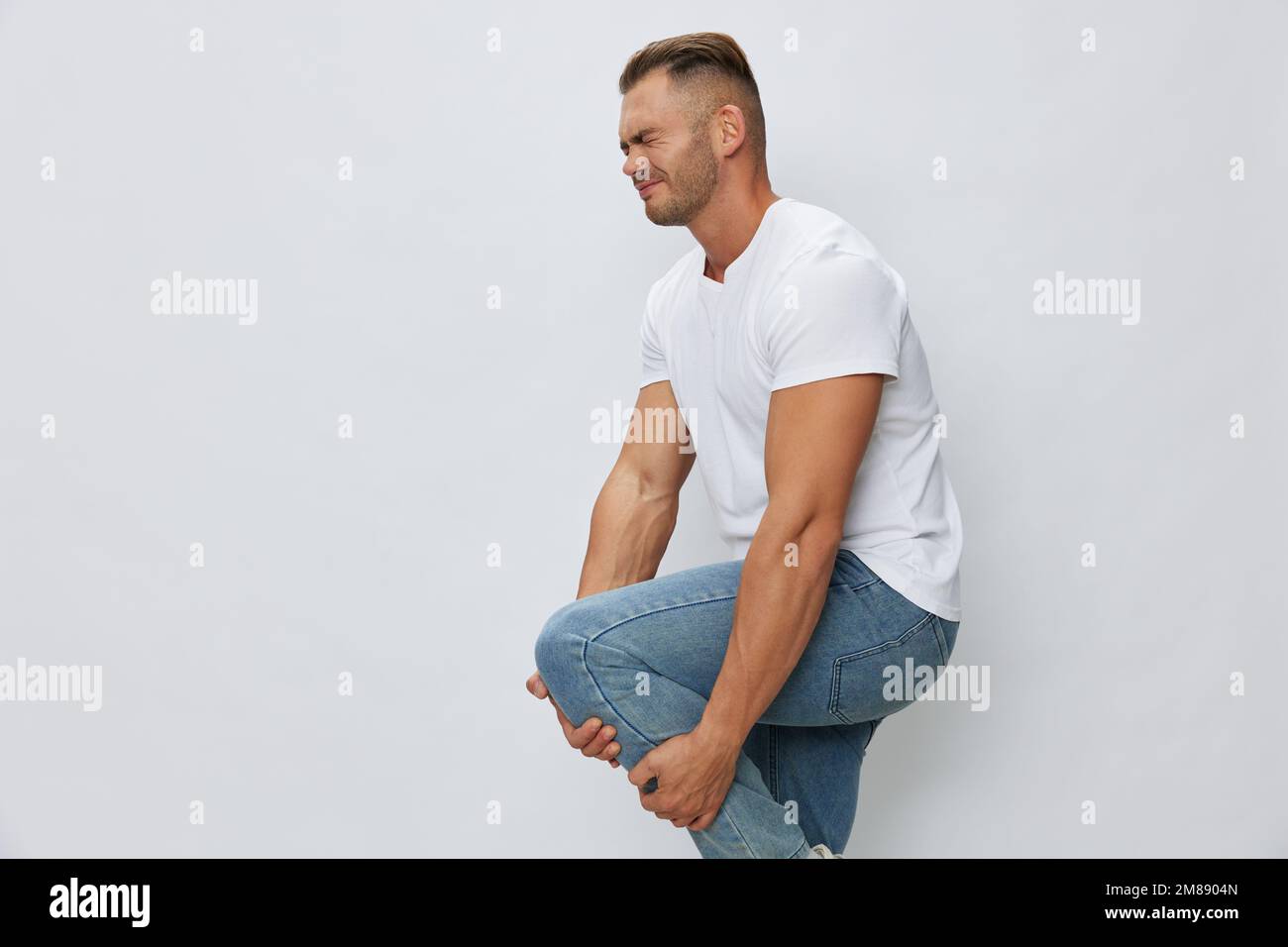 Man leg pain, muscle and ligament sprain, impact, in white T-shirt on ...