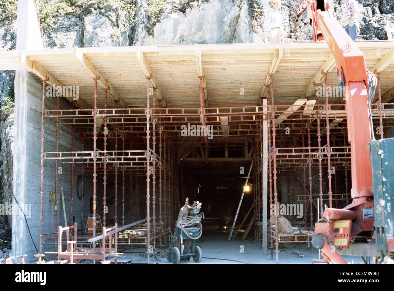 Civilian employees stand on top of braces as they construct a concrete ...