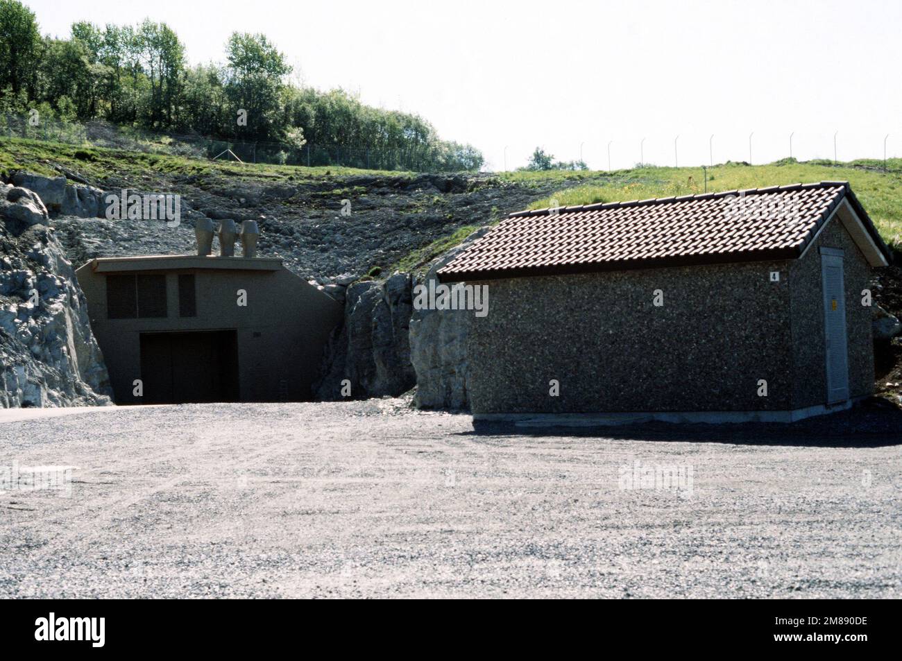 A generator shed stands in front of a concrete entryway leading to a ...