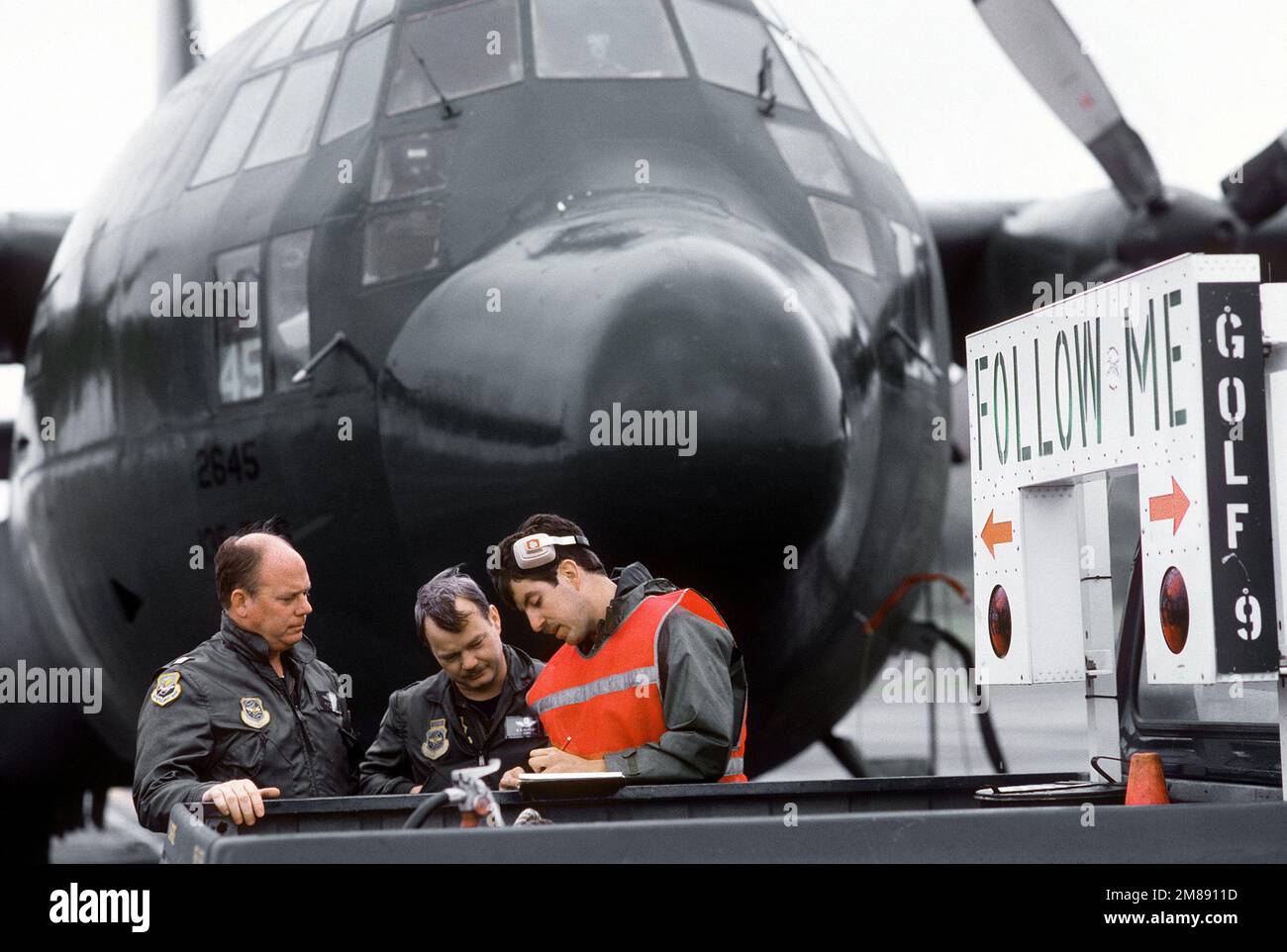 Leaning on his "Follow Me" truck beneath the nose of a C-130 Hercules ...