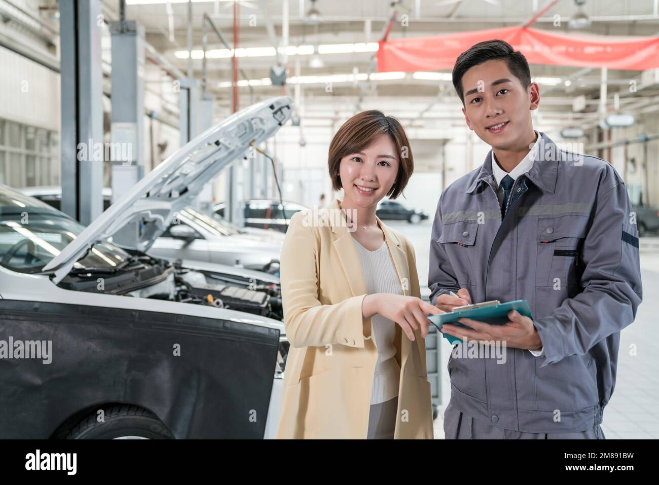 Repair shop mechanics of personnel with the customer Stock Photo - Alamy